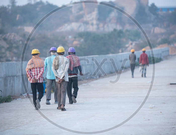 Image of Construction Daily Workers Walking Along a Road Wearing Safety ...