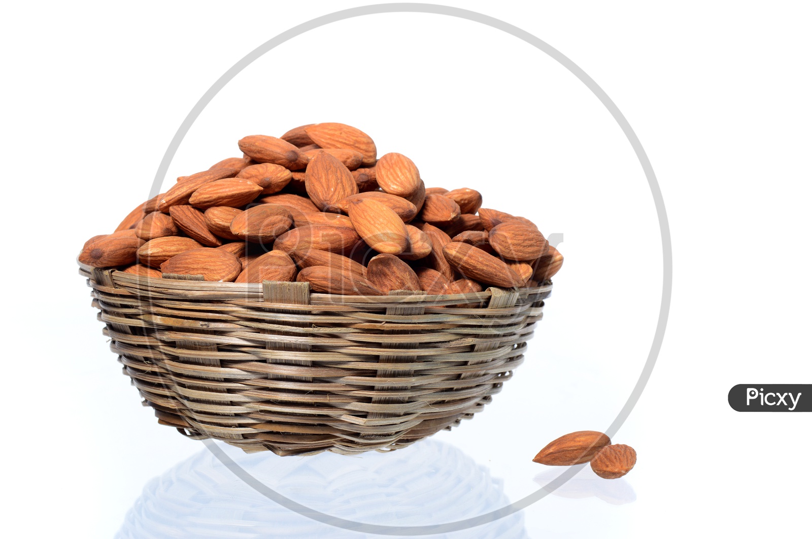 Image of Almonds Or Badam Nuts Heap On a Wooden Weaved Bowl On An ...