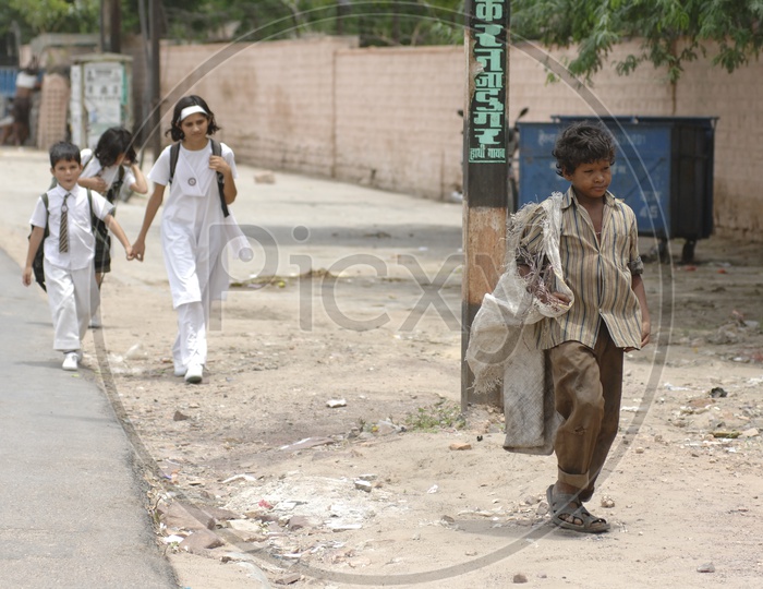 Image of Rag picker boy child in front of the school kids-DQ860155-Picxy