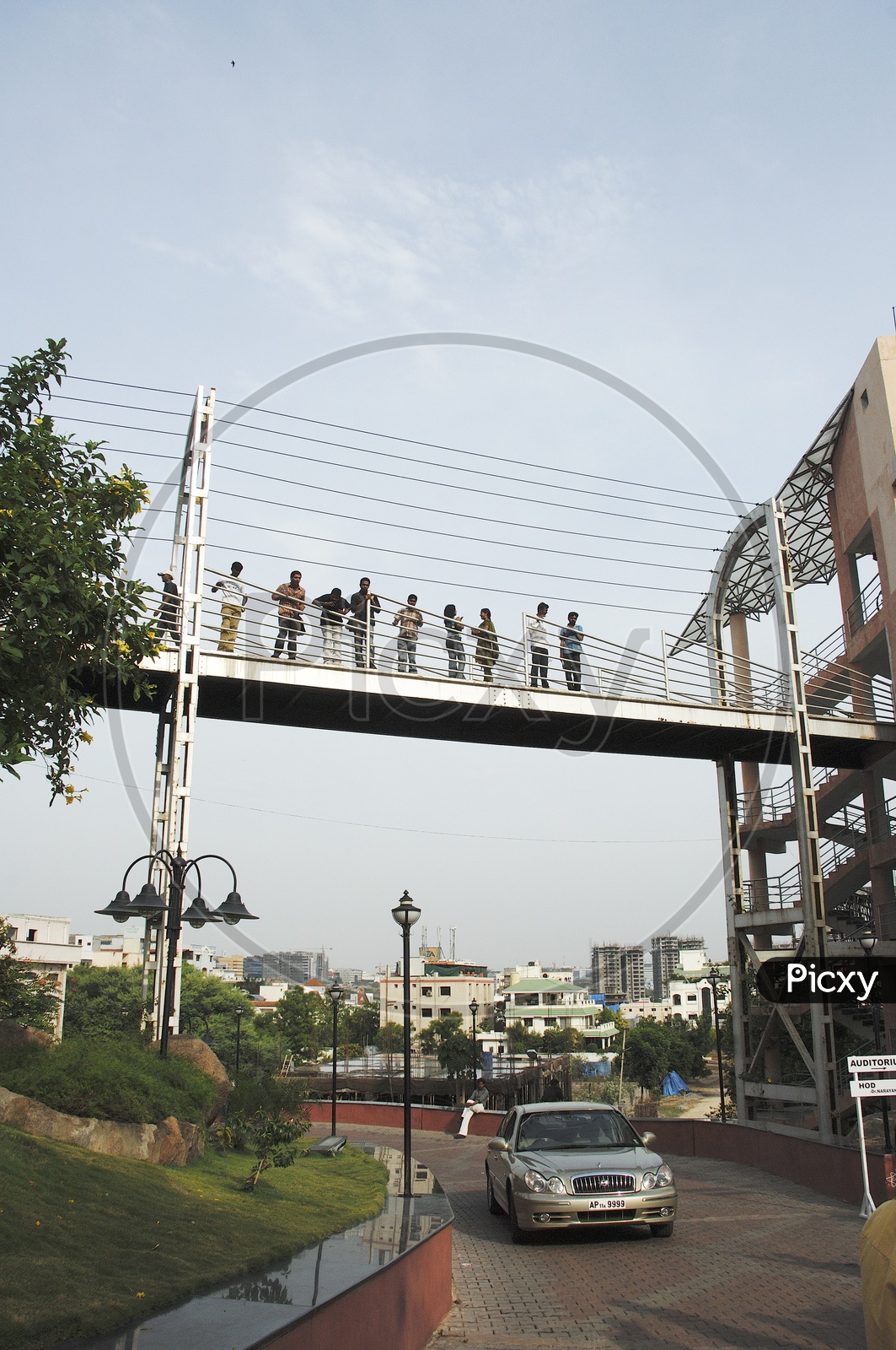 Image of People Standing On a Connecting Bridge to a Building-AW114162 ...