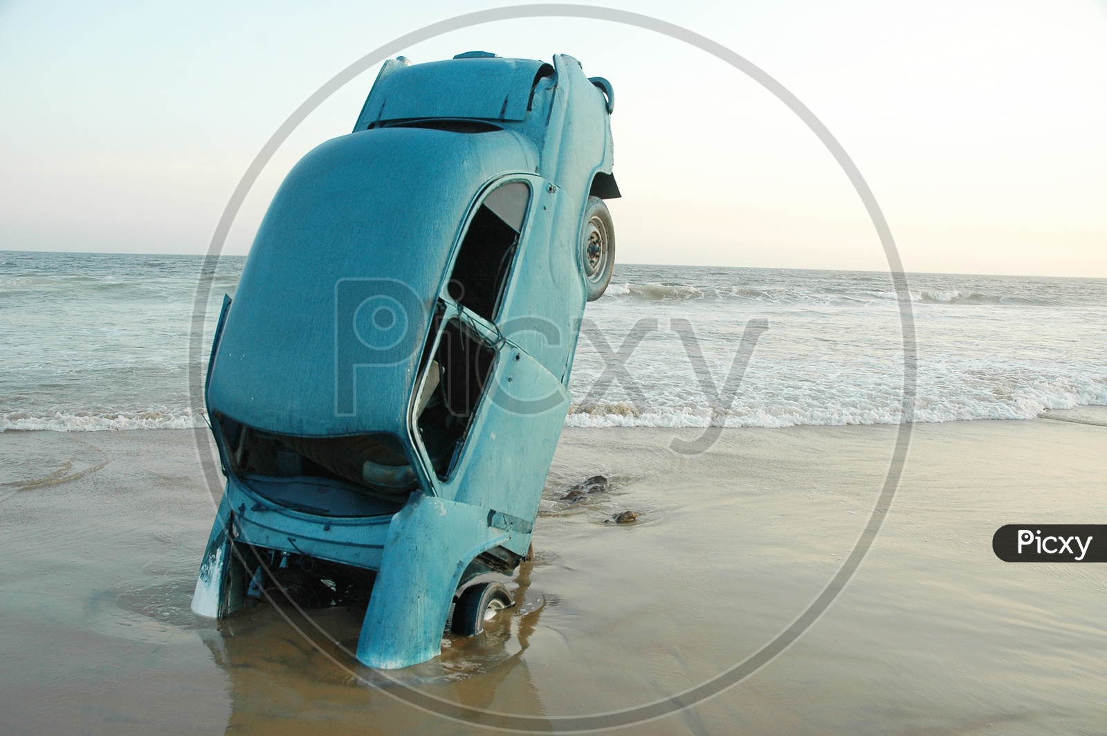 Image of An old blue car stuck in the sand at the beach-DS851159-Picxy