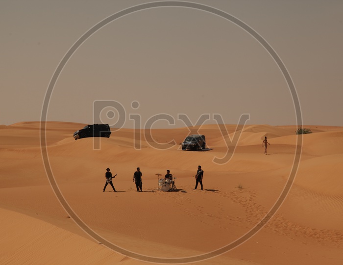 Image of A Music Band Performing In Sand dunes of A Desert-CV619773-Picxy