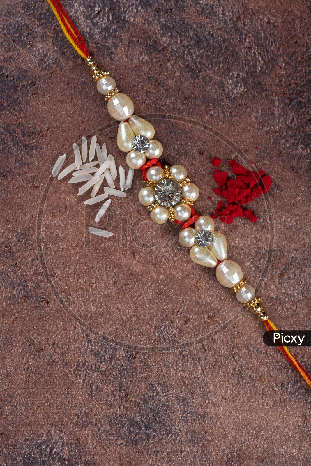 Image of An Elegant Rakhi With Rice Grains And Kumkum On a Stone ...