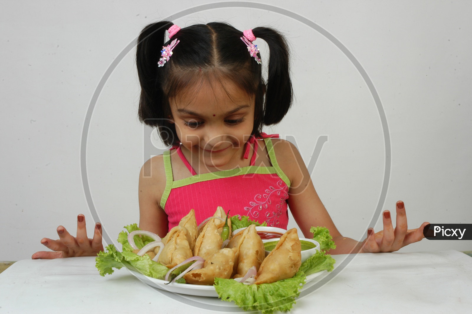 Image of An Indian Girl Kid At Samosas Plate With an Expression on an ...