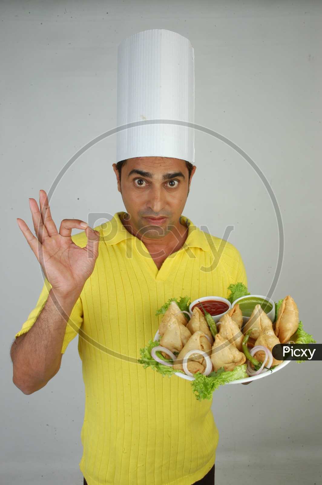 Image of An Indian Chef In Kitchen Apron And Cap Holding Samosas Plate ...