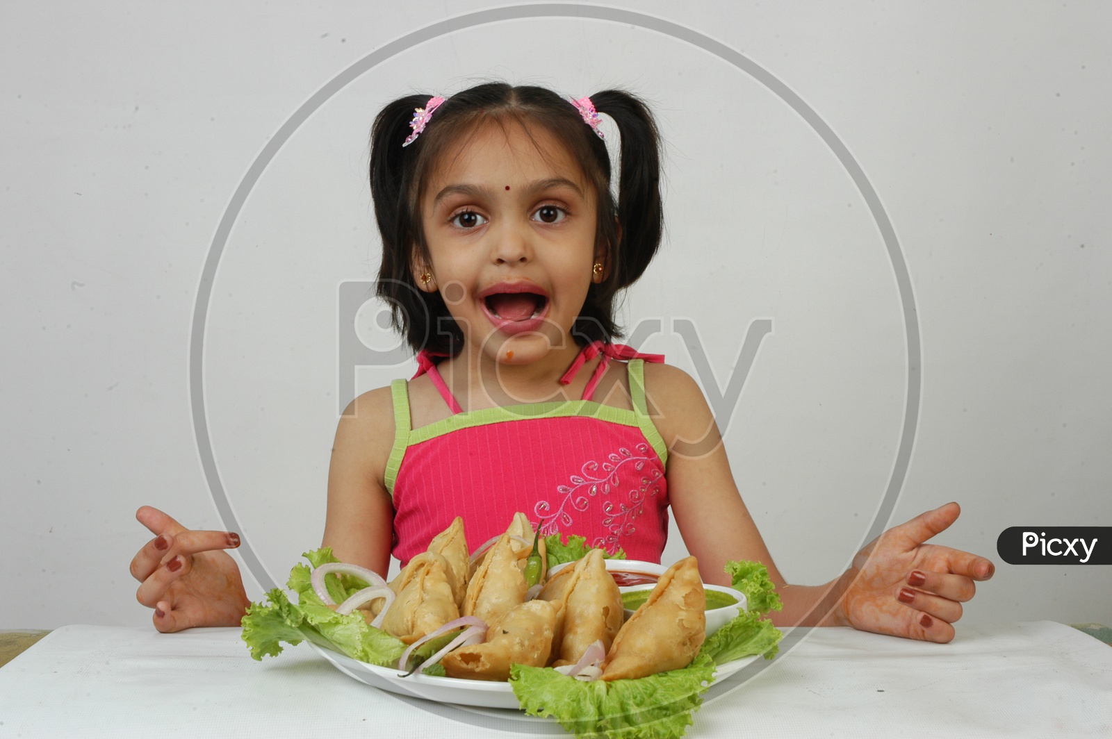 Image of An Indian Girl Kid At Samosas Plate With an Expression on an ...