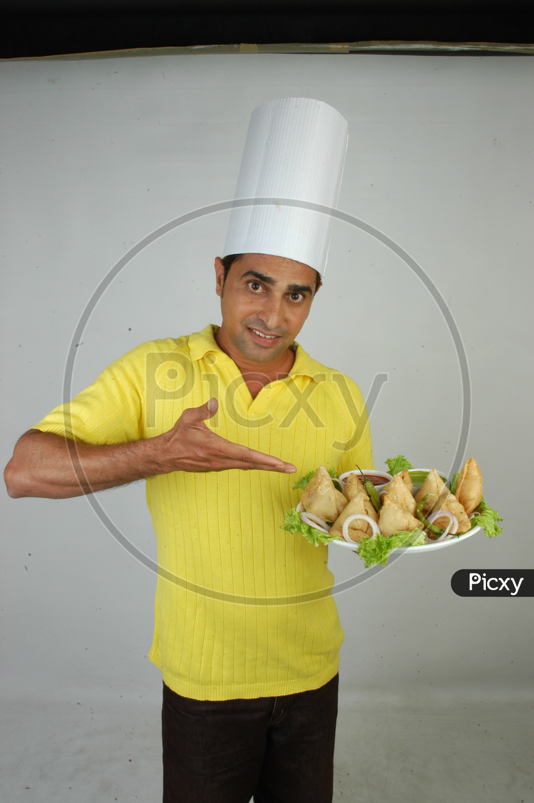 Image of An Indian Chef In Kitchen Apron And Cap Holding Samosas Plate ...