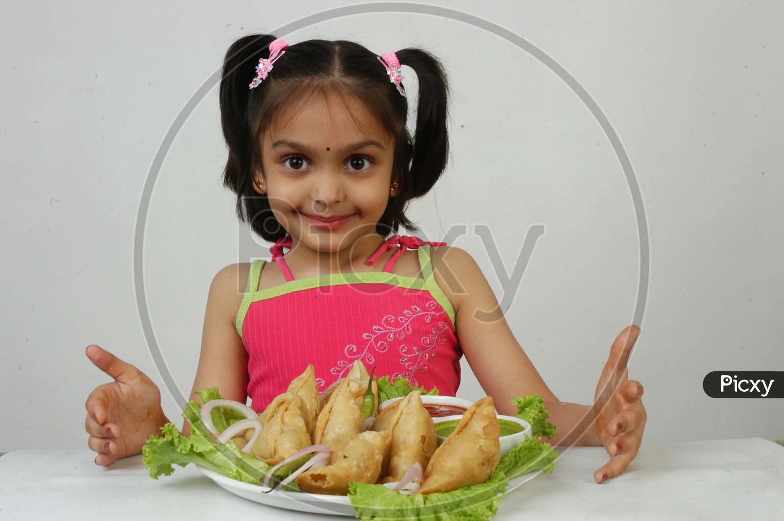 Image of An Indian Girl Kid At Samosas Plate With an Expression on an ...