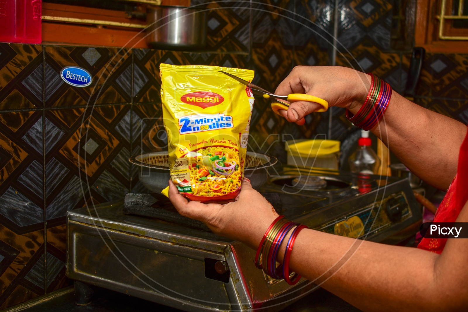Image of Woman cooking Maggi instant noodles in kitchen.-YA822601-Picxy