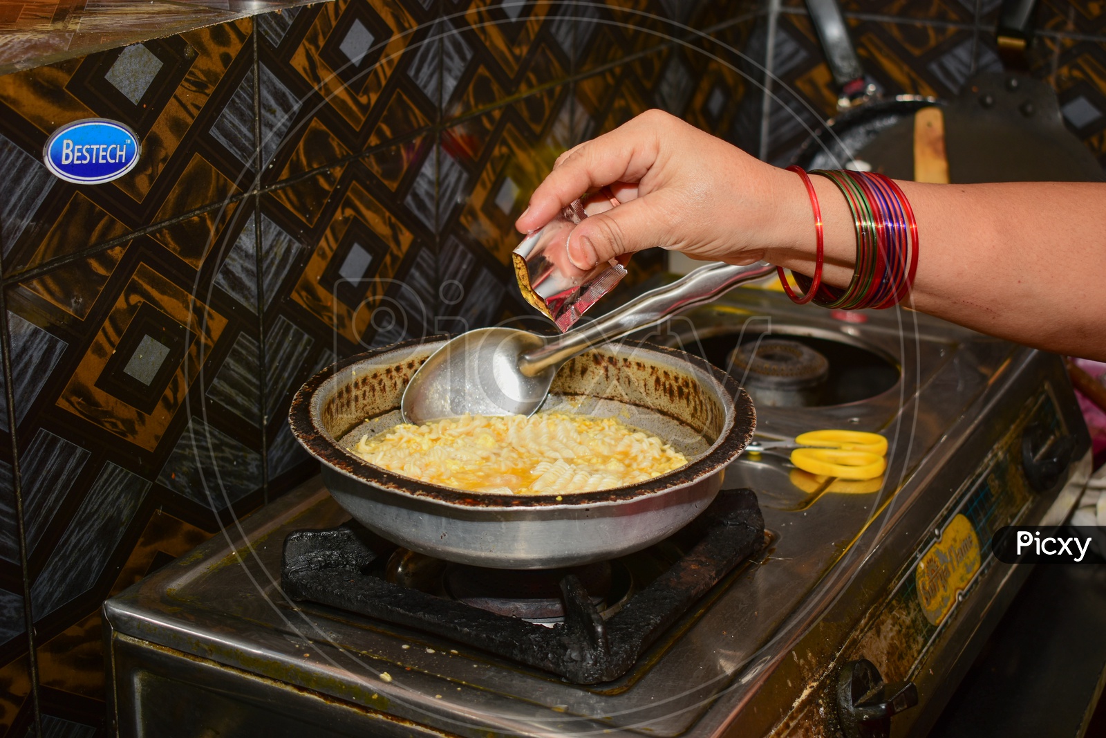Image of Woman cooking Maggi instant noodles in kitchen.-TV739886-Picxy