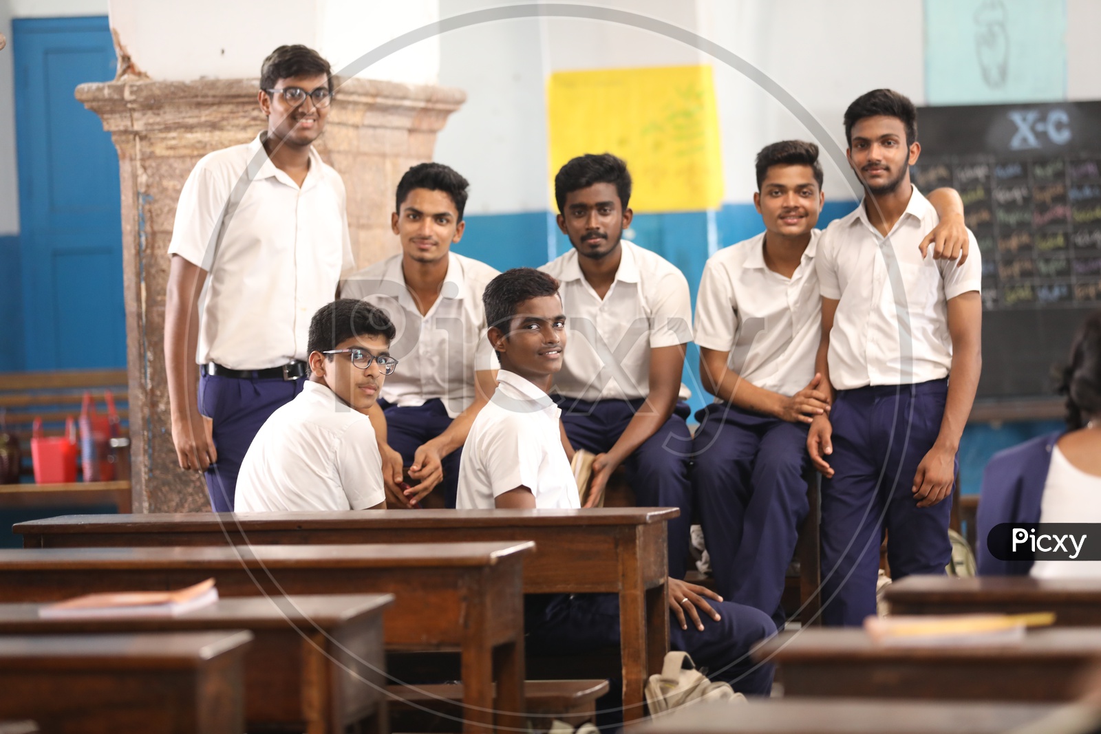 Image of School Students Posing By Sitting on Benches In a Classroom ...