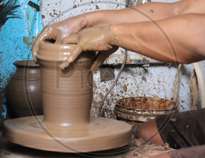 Image of A Professional Potter Making Pots by Turning Potter Wheels ...