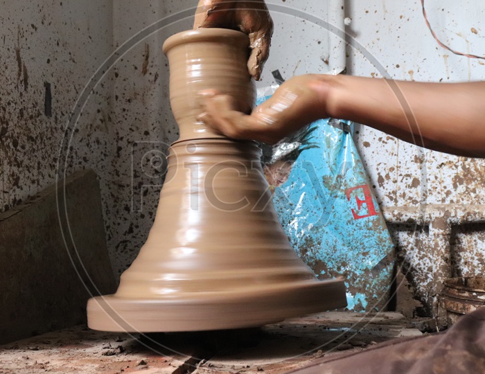 Image of A Professional Potter Making Pots by Turning Potter Wheels ...