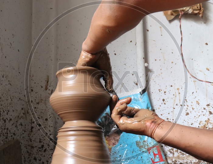 Image of A Professional Potter Making Pots by Turning Potter Wheels ...