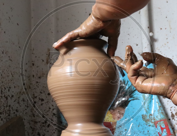 Image of A Professional Potter Making Pots by Turning Potter Wheels ...