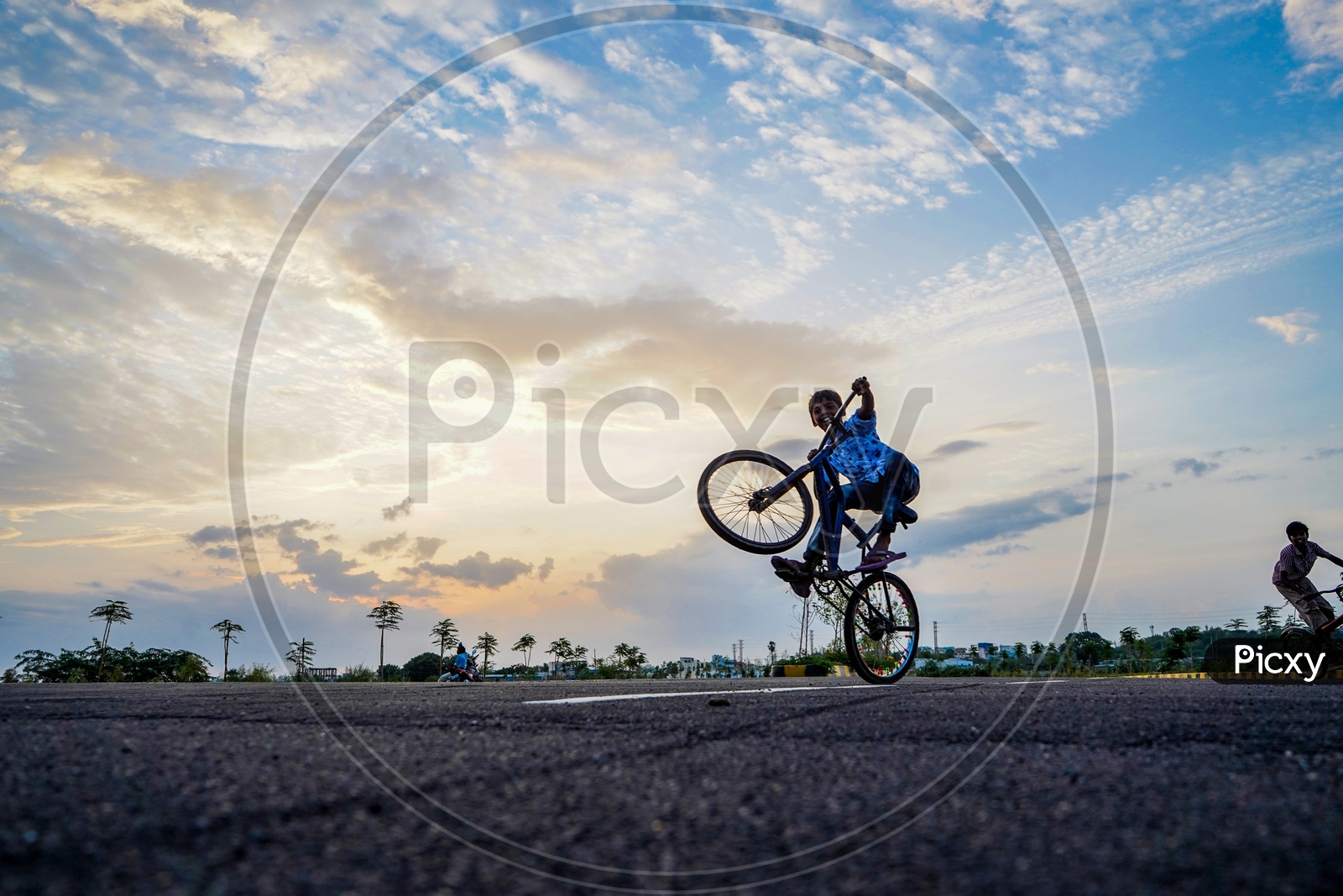 Image of Happy Or Joyful Indian Young Boys Performing Bicycle Stunts-XI234047-Picxy