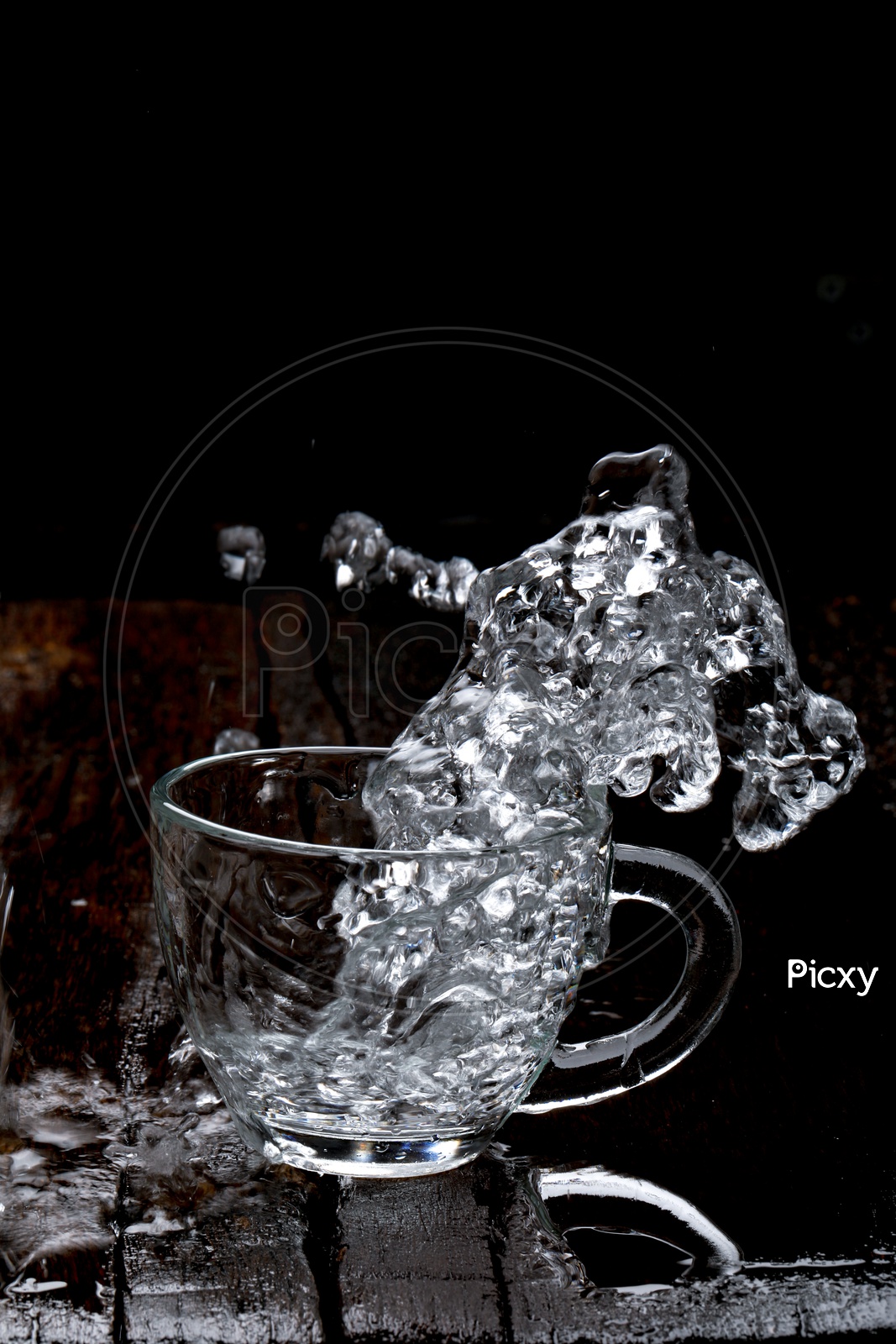 Image of Water Filled In an Glass Tea Cup and Water Splash On an Wooden ...