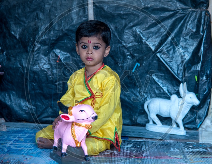 Image of Indian Child With Holy Scared Cow Idol-OK323539-Picxy