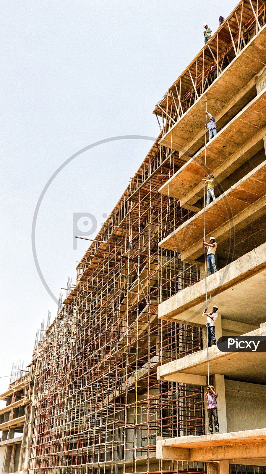 Image of Team Work Of Construction Workers Carrying A Long Iron Bar ...