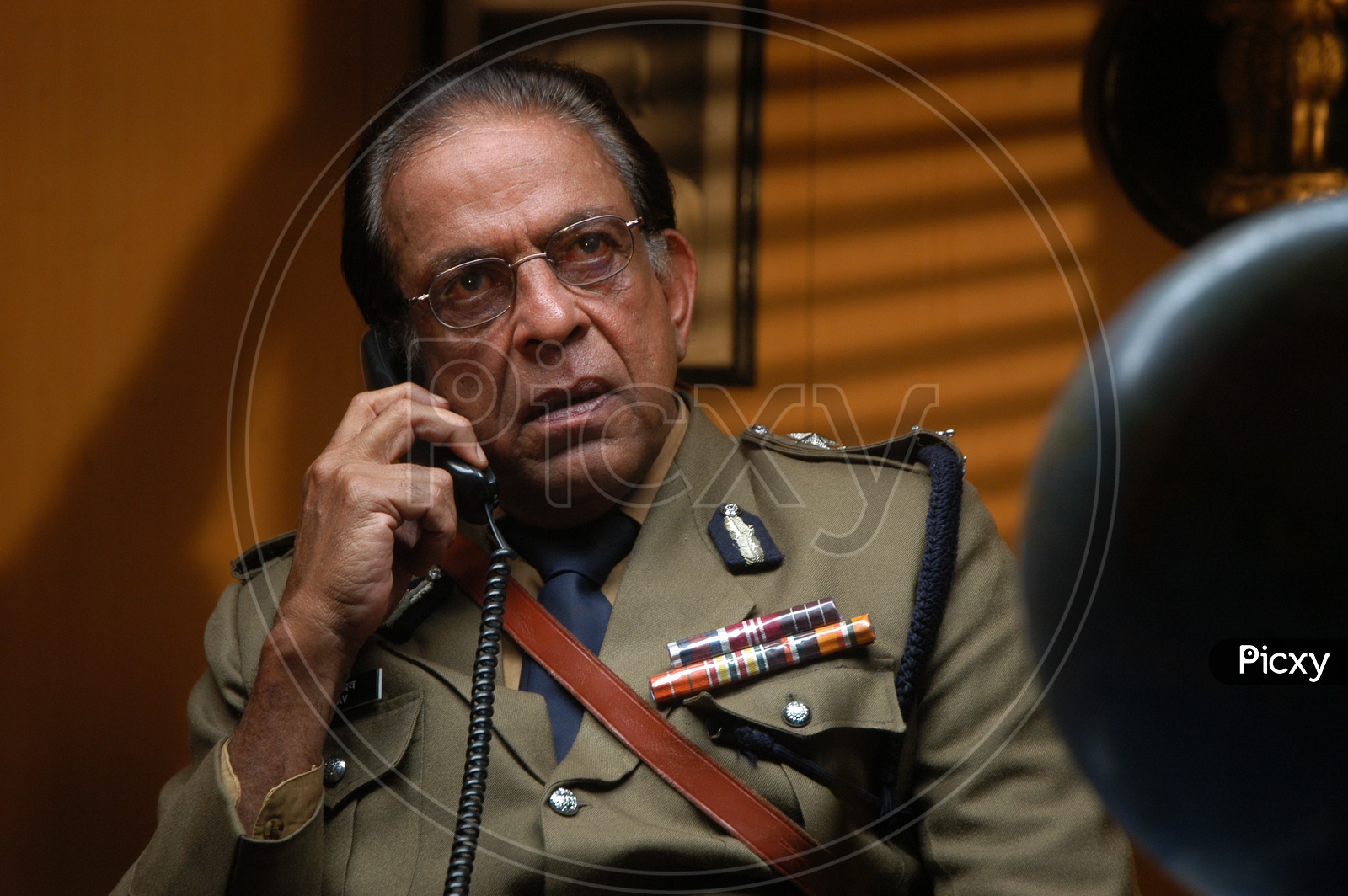Image of A Man in a Police uniform talking on Landline Phone-ZP388635-Picxy