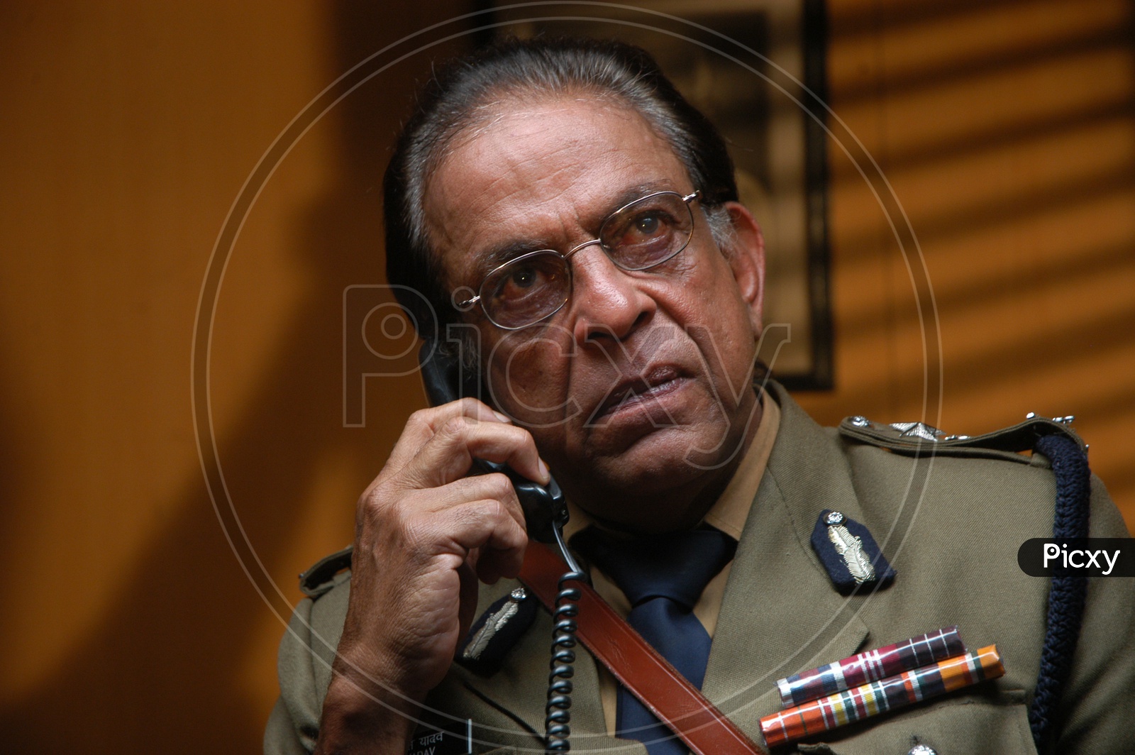 Image of A Man in a Police uniform talking on Landline Phone-SR375234-Picxy