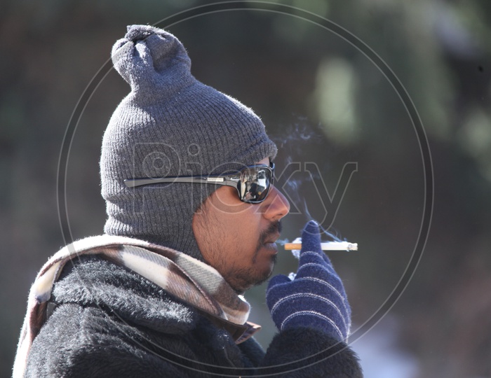 Image of Man Smoking Cigarette at Snow Capped Mountains-VE268261-Picxy
