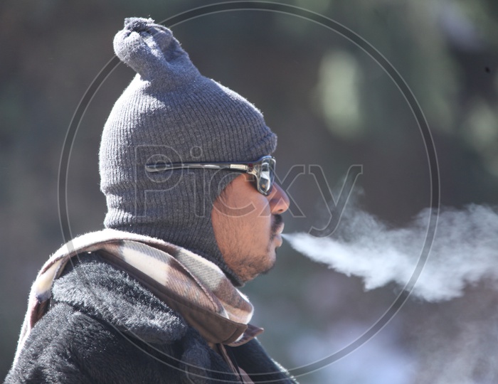 Image of Man Smoking Cigarette at Snow Capped Mountains-VE268261-Picxy