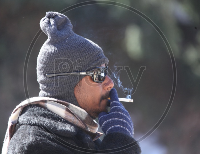 Image of Man Smoking Cigarette at Snow Capped Mountains-VE268261-Picxy