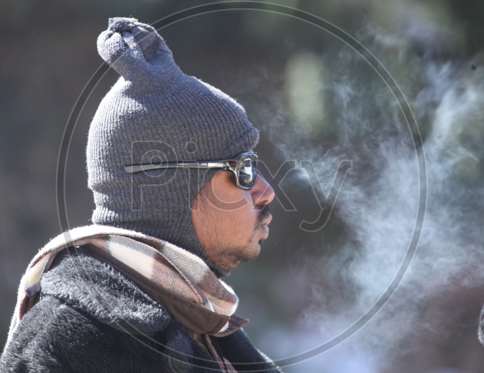 Image of Man Smoking Cigarette at Snow Capped Mountains-VE268261-Picxy