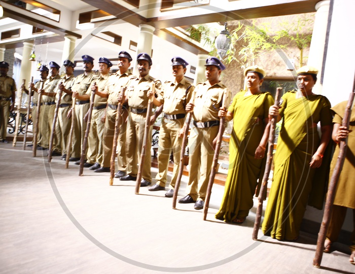 Image of Police Man And Woman Holding Wooden Sticks In Hand in a Police ...