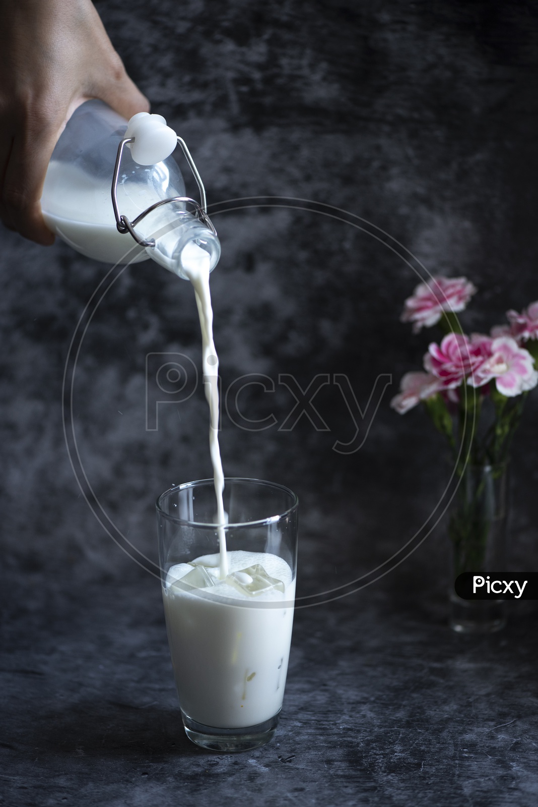 Image of Fresh milk being poured into a glass with ice-VL773750-Picxy