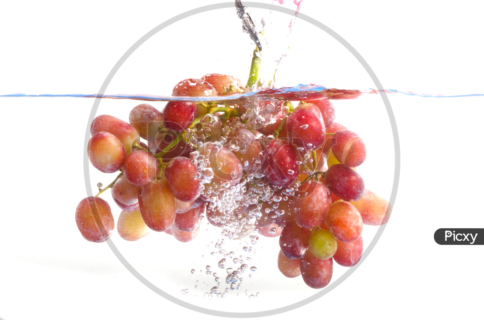 Image of Fresh Red Grapes Dropped Into Water With Splash Over an Isolated White Background ...