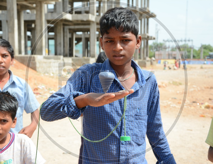 Image of Indian Children Playing with Spinning Top Or Bongaram-UM943794 ...
