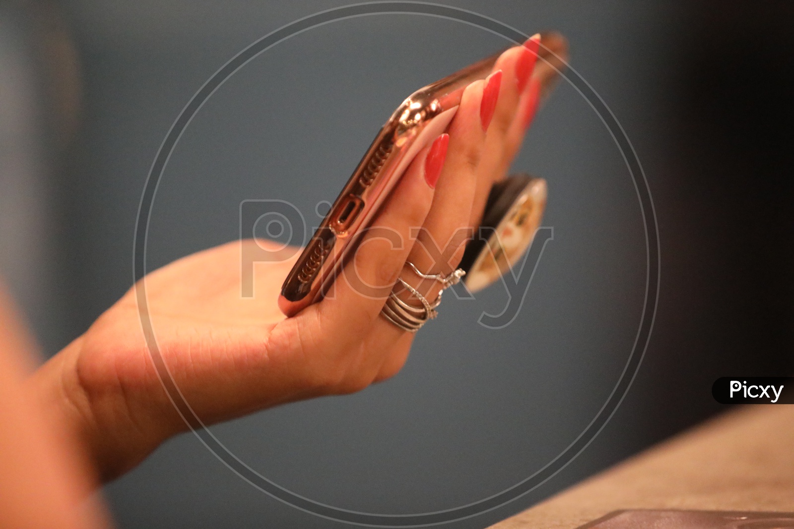 Image of Indian Woman holding a Phone using Pop Socket-AO140146-Picxy