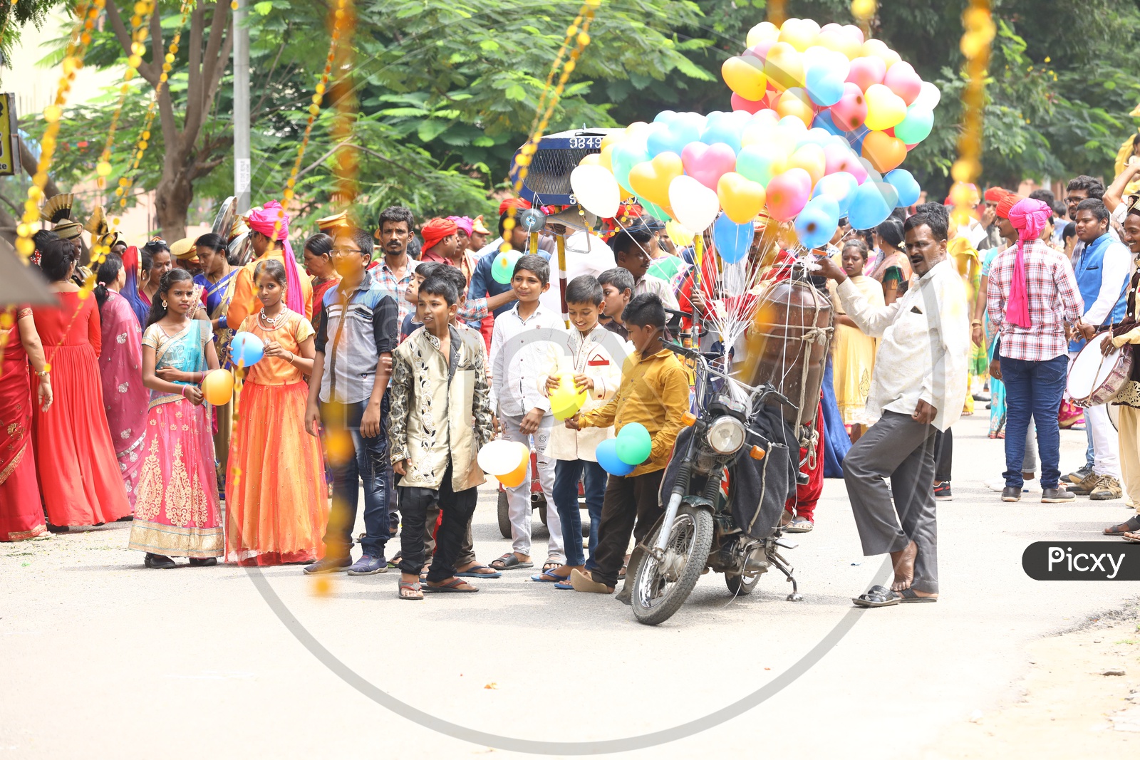 Image of Indian children standing by the balloon seller-AG051653-Picxy