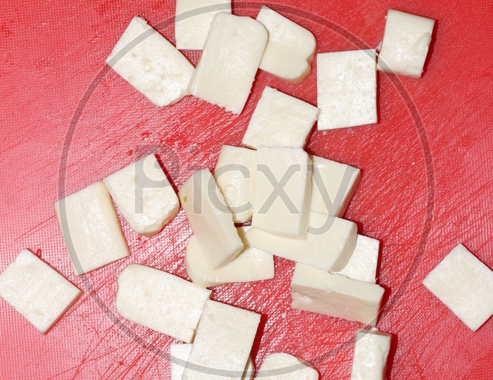 Image of Freshly Chopped Paneer Pieces on a Cutting Table-LK443669-Picxy