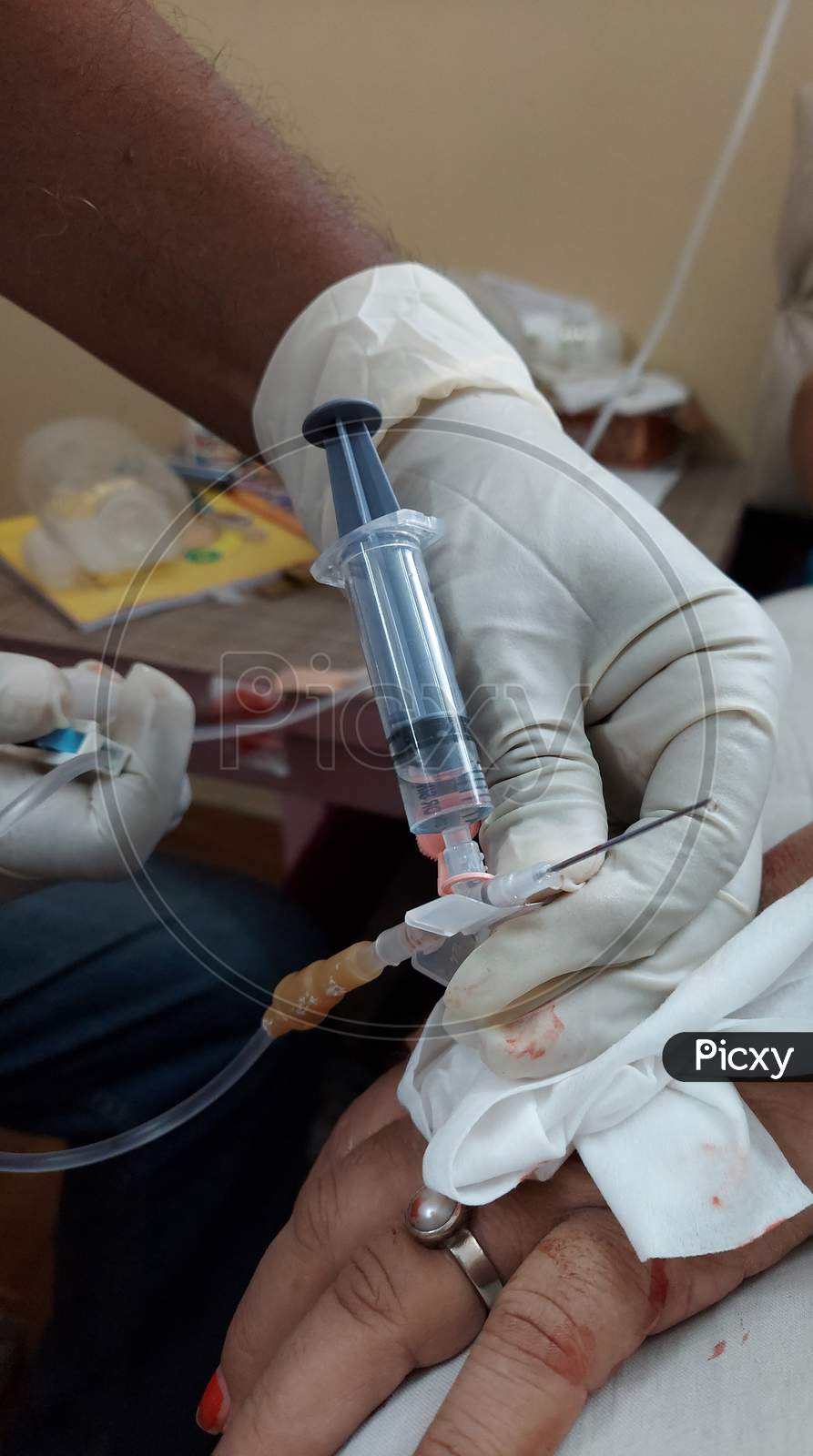 Image of A close up short of two hands of a doctor with an intravenous ...