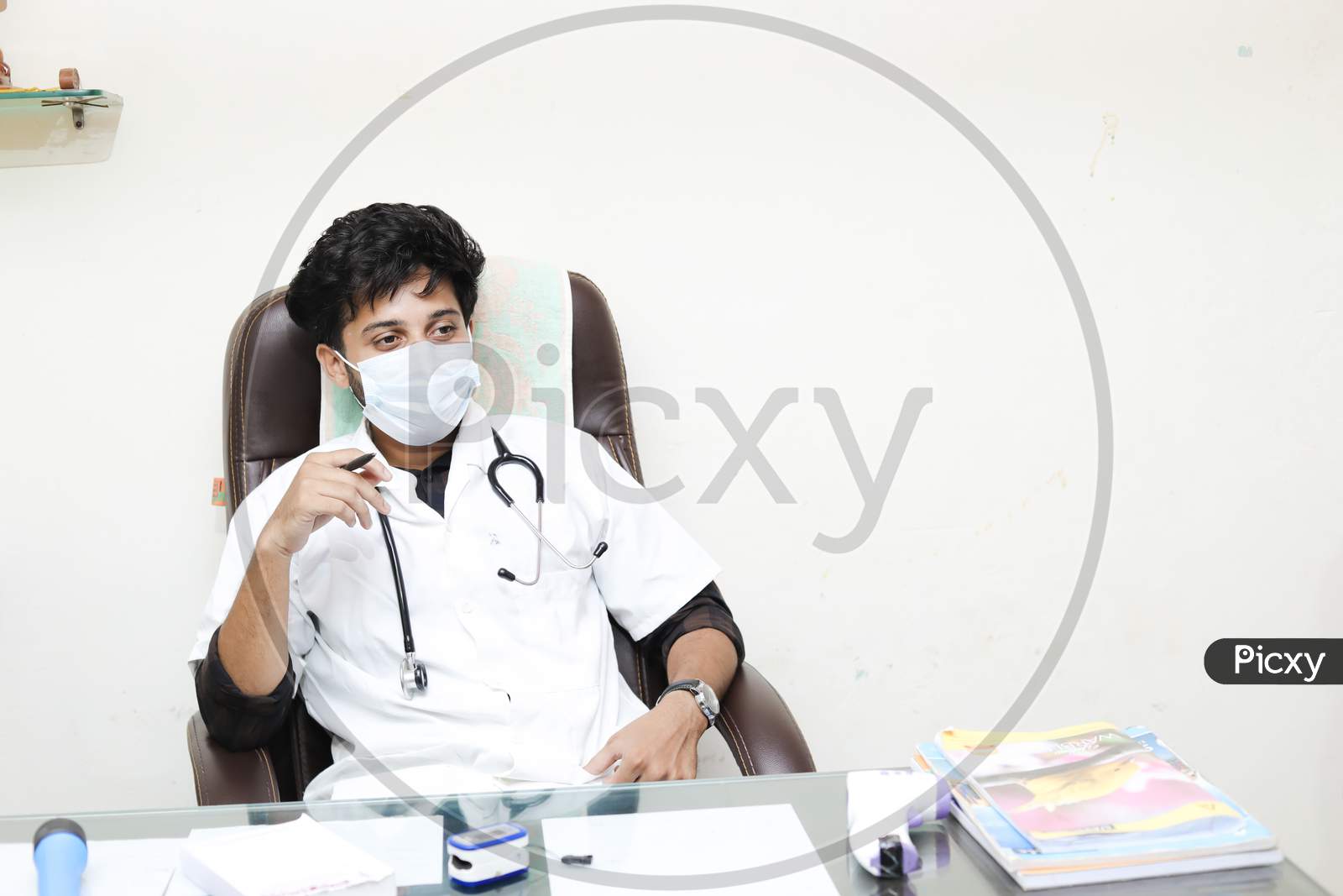 Image of Indian young doctor sitting on chair, doctor office, doctor in ...