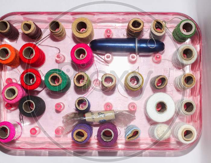 Image of semi transparent pink box with threads on white background ...