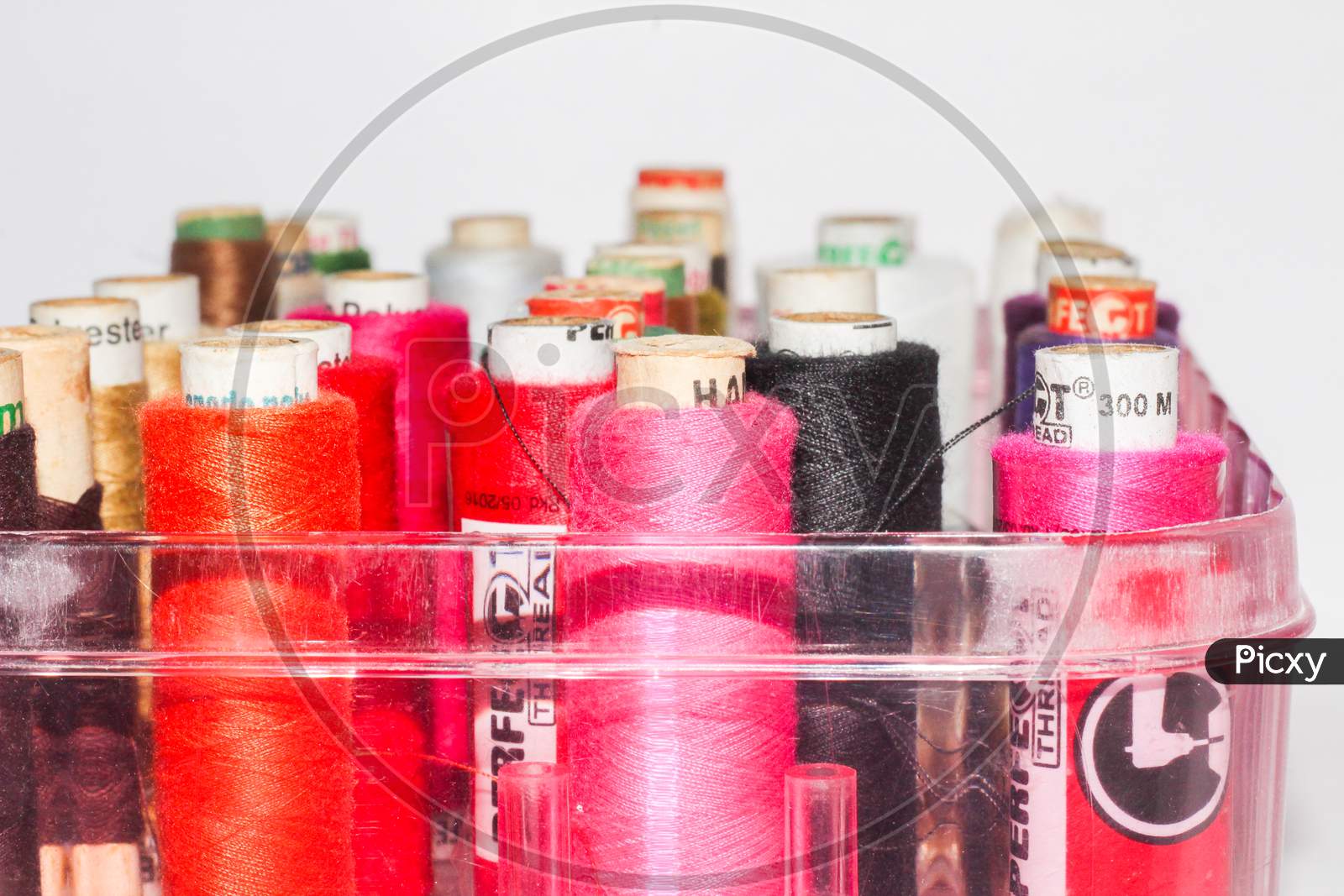 Image of semi transparent pink box with threads on white background ...