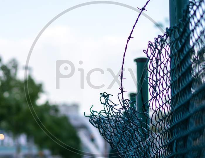 Image of Green damaged wire-mesh fence is ruined after collision with ...