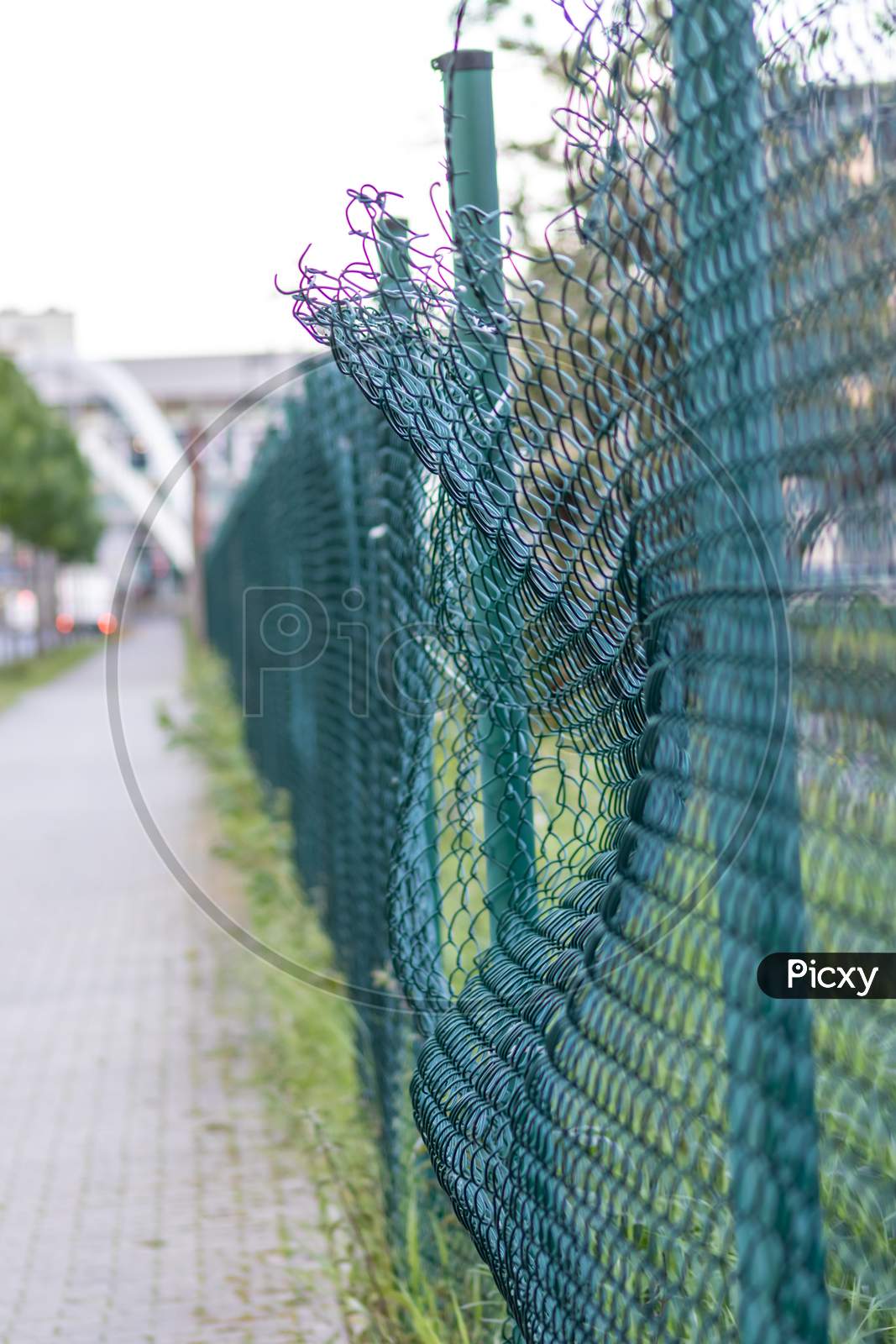Image of Green damaged wire-mesh fence is ruined after collision with ...