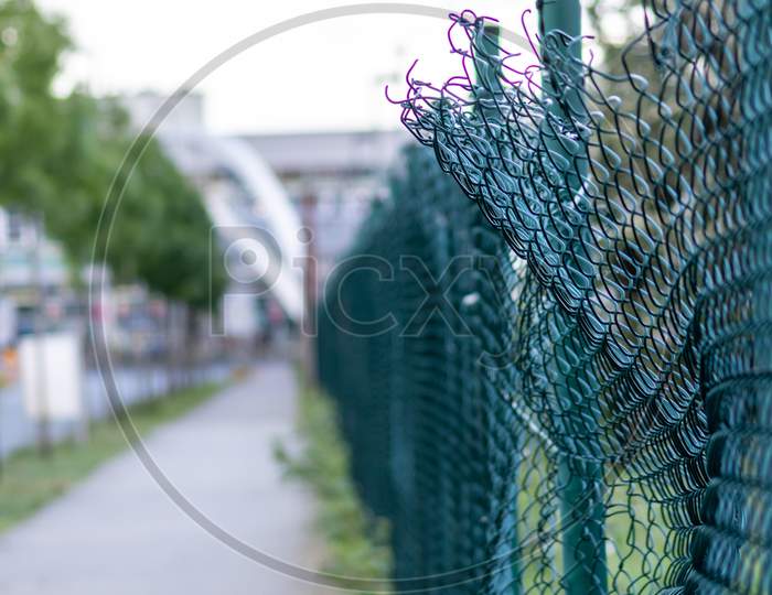 Image of Green damaged wire-mesh fence is ruined after collision with ...