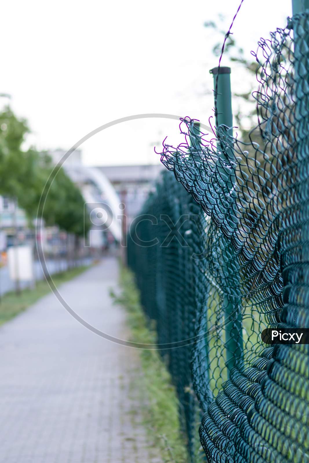 Image of Green damaged wire-mesh fence is ruined after collision with ...