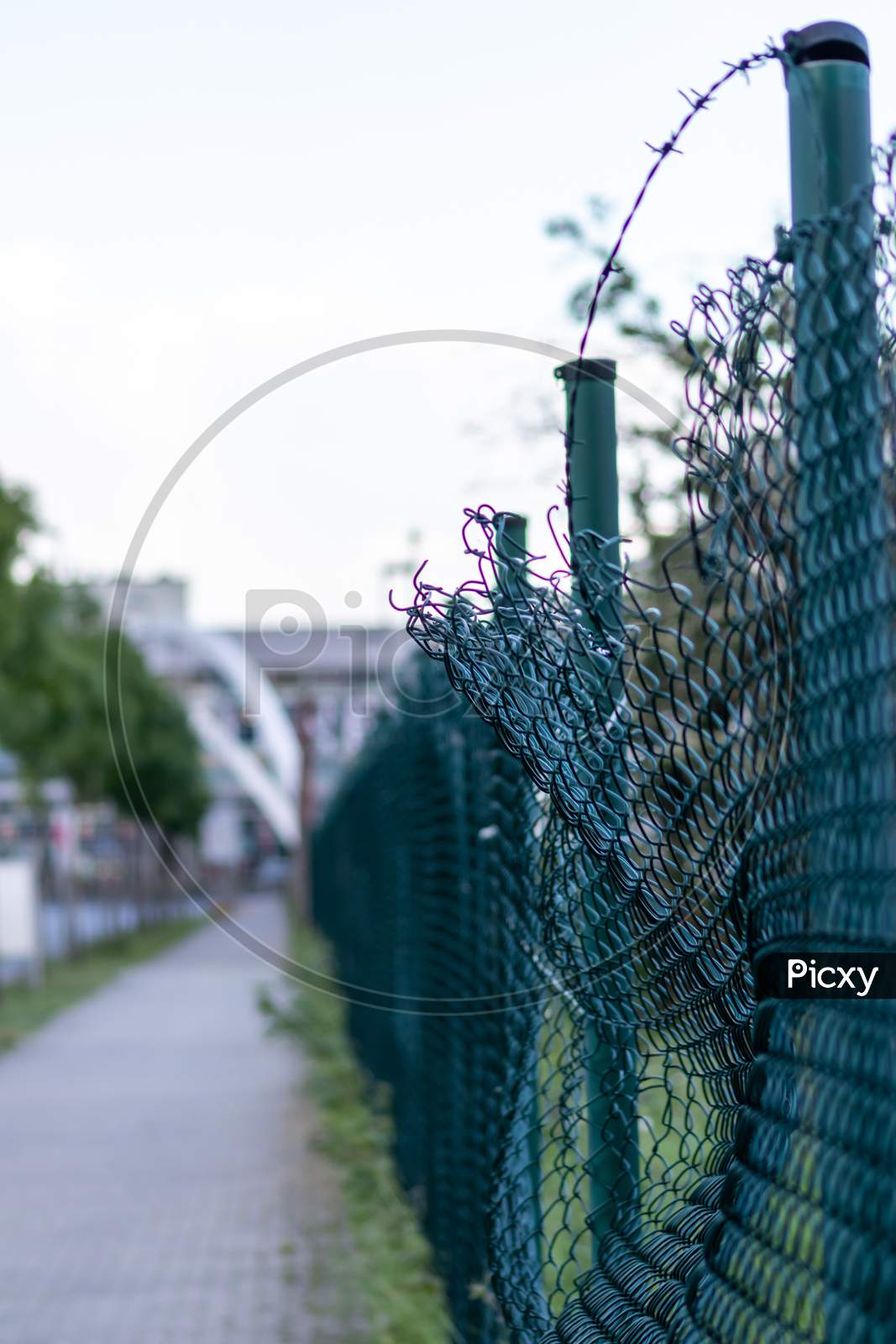 Image of Green damaged wire-mesh fence is ruined after collision with ...