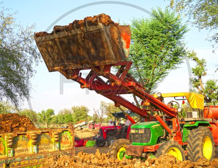 Image of Loader Tractor Rides On Agriculture Field To Carry Out Loading ...