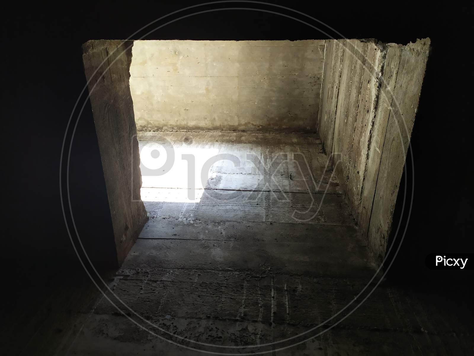 Image of Dark ventilation shaft with sunlight through a metal grid ...