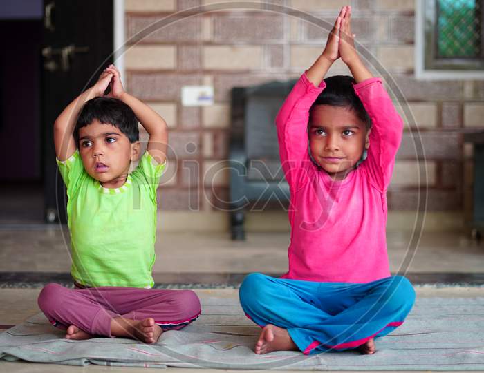 Image of Kids Yoga. Little Indian Boy And Girl Doing Yoga Exercise And Watching Instructions On ...