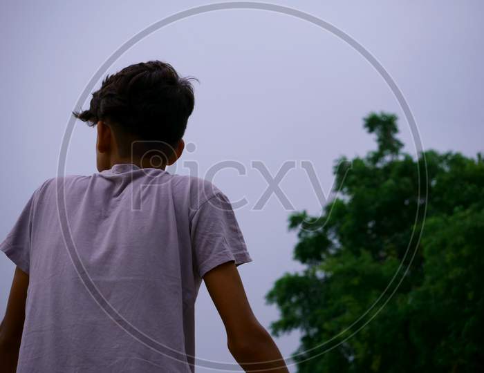 Image of Indian Boy Back Pose With Spreading Hand On Sky Background ...