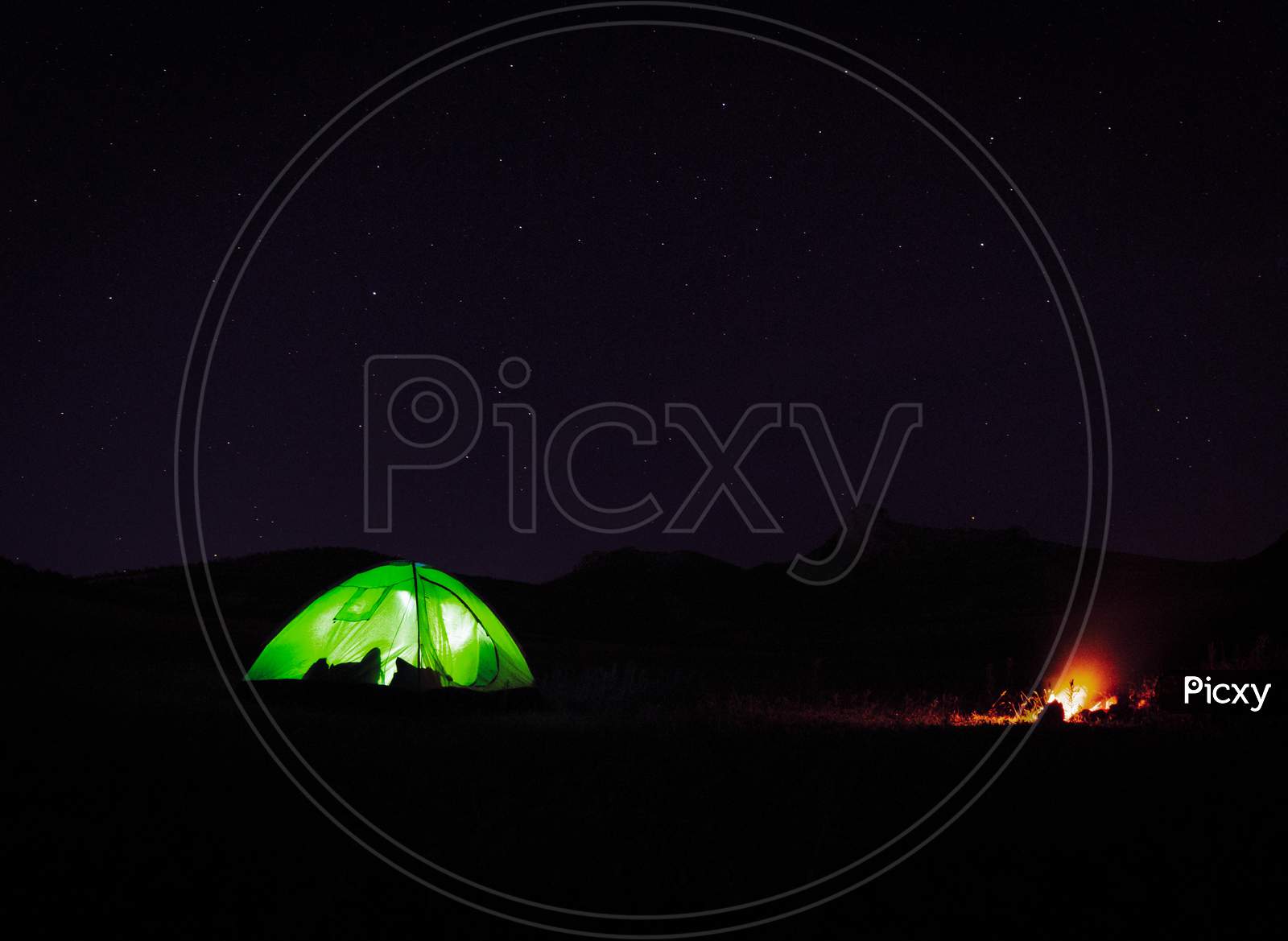 Image of Illuminated Green Tent Standing By Camp Fire In Nature At ...